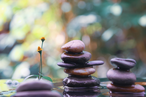 Relaxation and peace mood Balanced rocks pyramid on water with Golden light